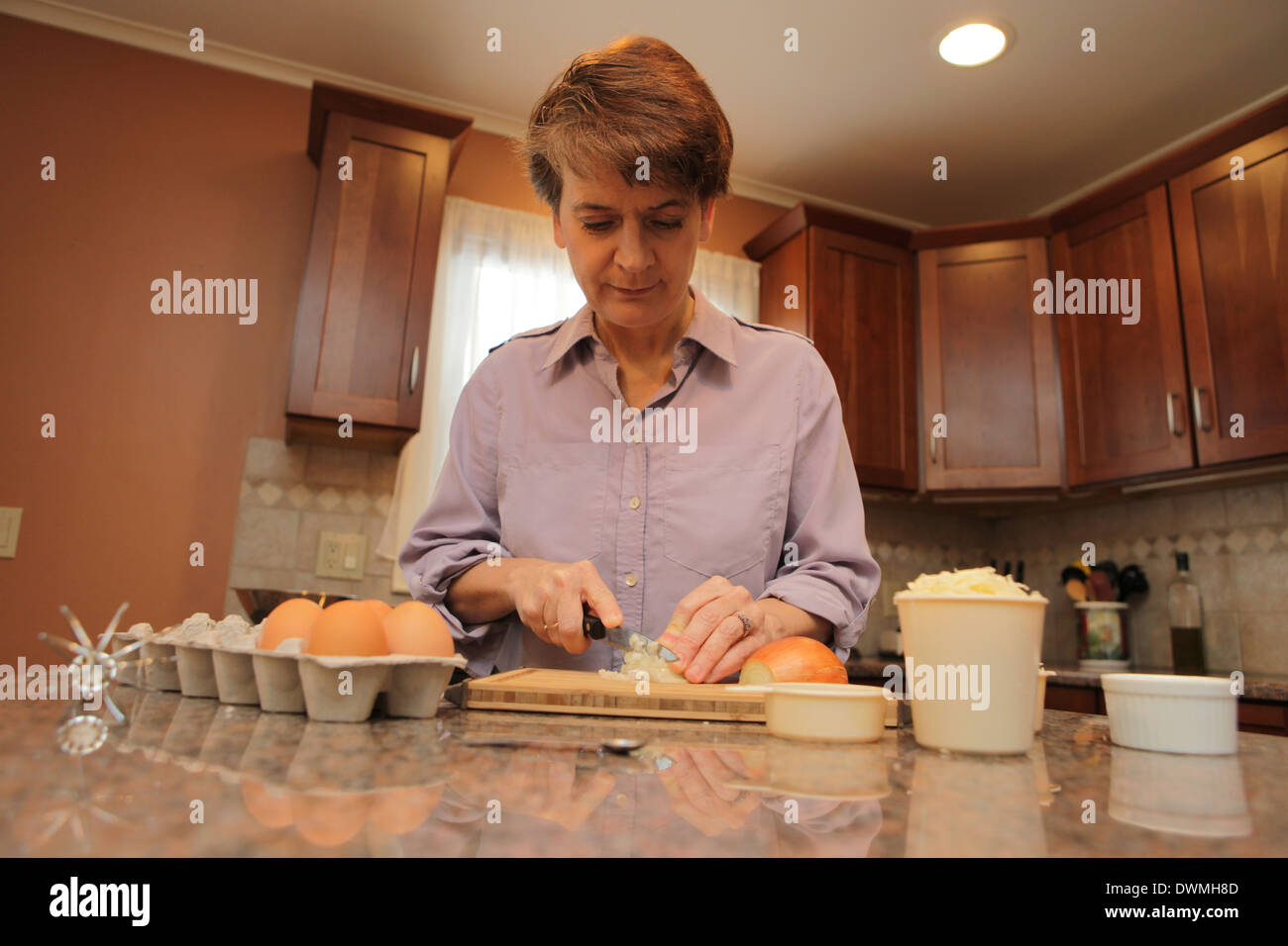 Woman preparing food in her kitchen, New York, USA, © Katharine ...