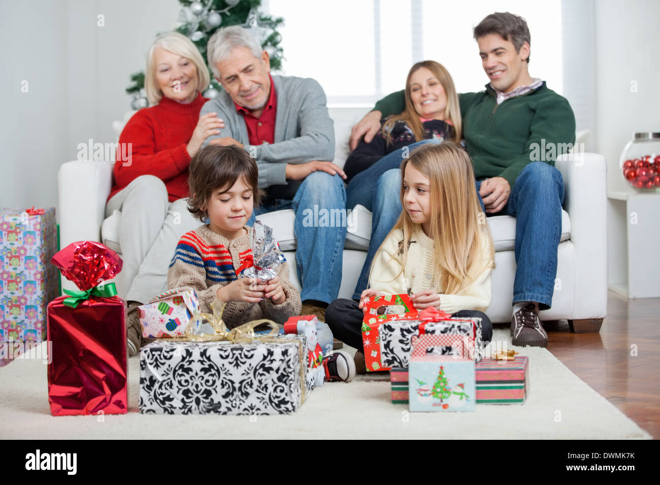 Boy girl open presents christmas tree hi-res stock photography and ...