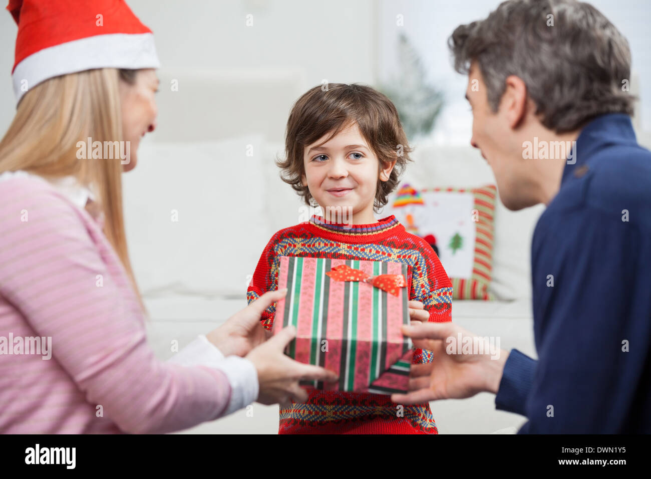 Boy Receiving Christmas Gift From Parents Stock Photo - Alamy