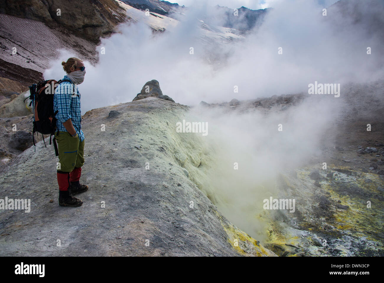Tourists standing by smoking fumaroles on Mutnovsky volcano, Kamchatka ...