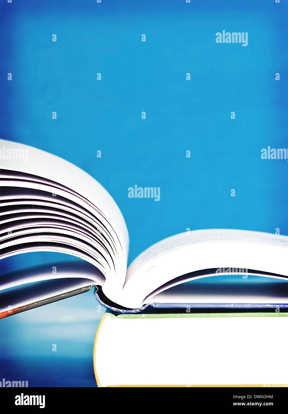 Open book on blue background Stock Photo - Alamy