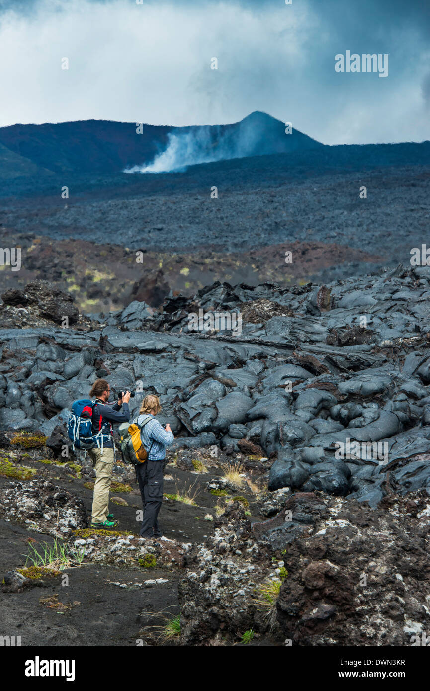Tourists standing at a cold lava stream after an eruption of Tolbachik ...