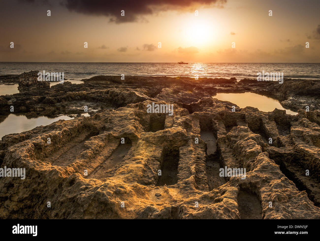 sunset over the sea and rocky coast with ancient ruins in Mahdia ...
