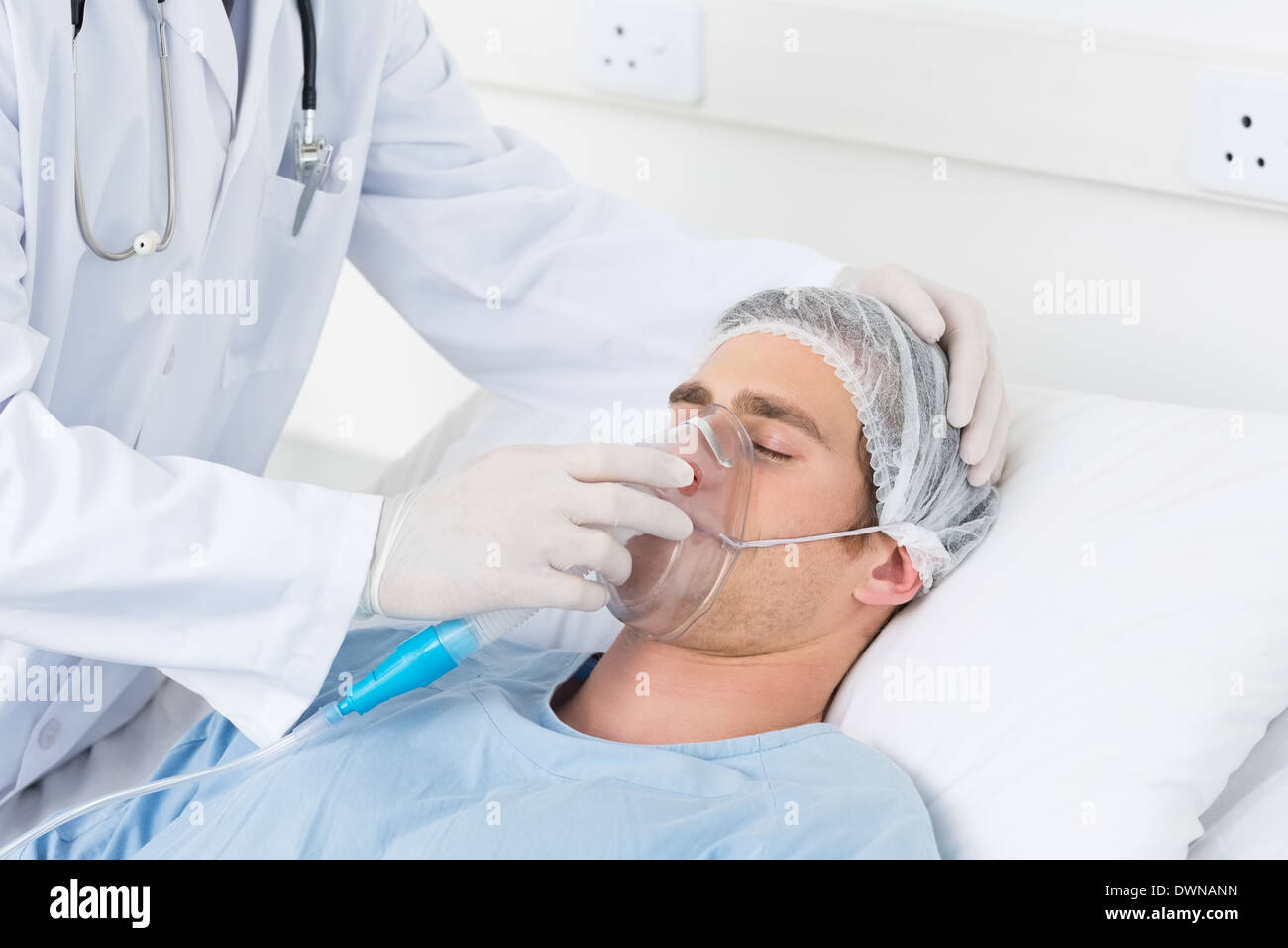 Doctor adjusting oxygen mask on patient Stock Photo - Alamy