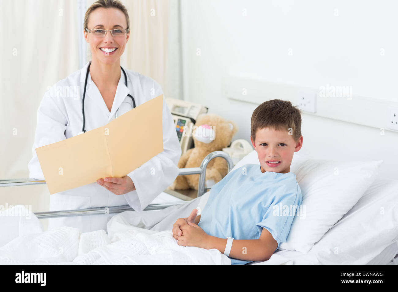 Female doctor with boy in hospital bed Stock Photo - Alamy