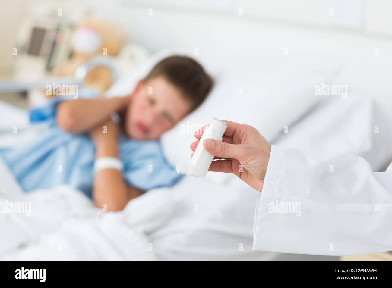 Doctor holding asthma inhaler with boy in hospital Stock Photo - Alamy