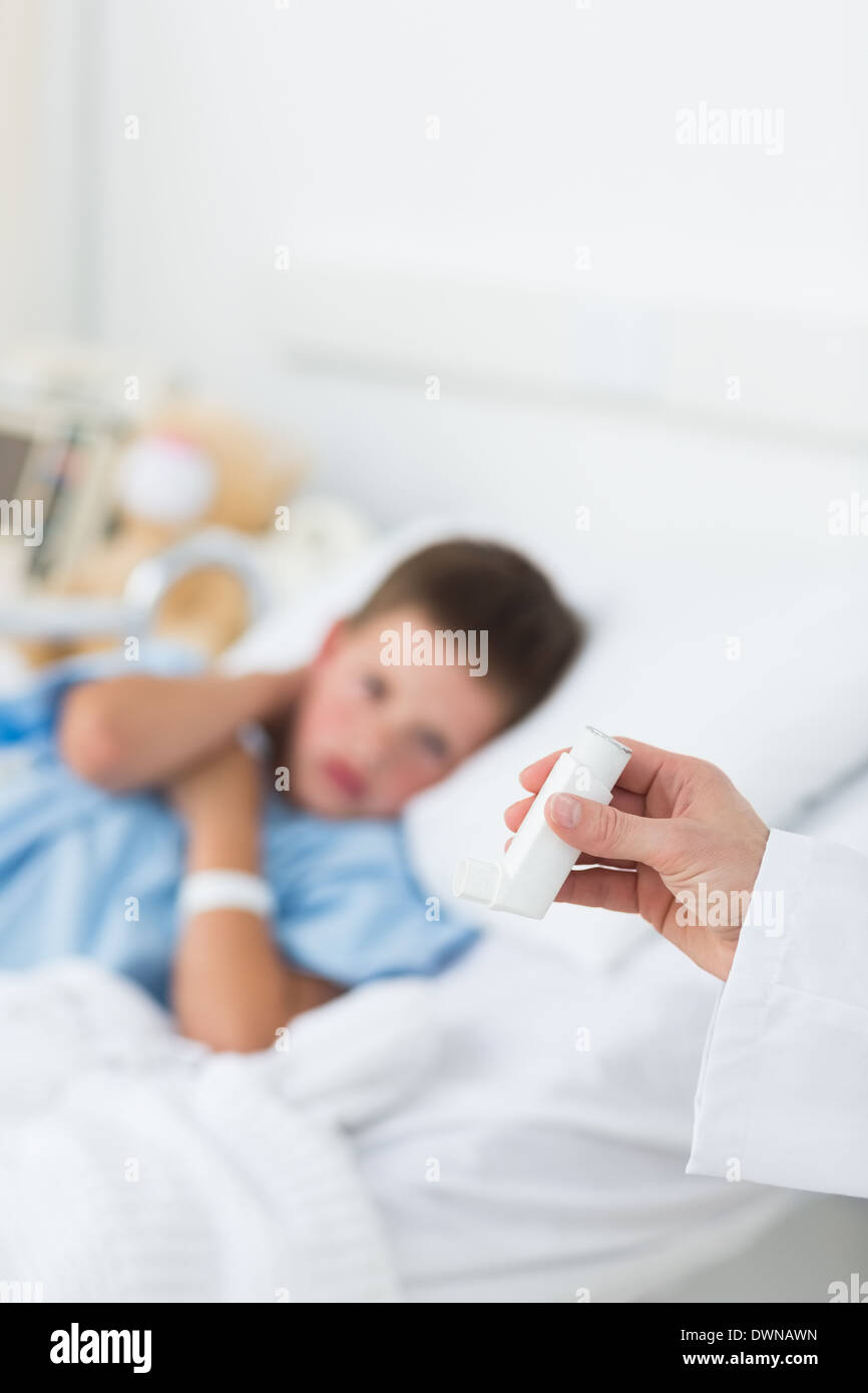 Doctor holding asthma inhaler with boy in hospital Stock Photo - Alamy