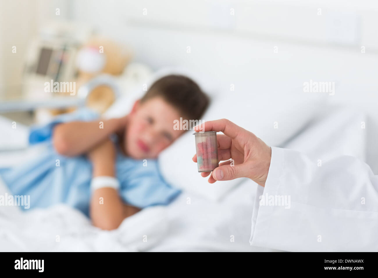 Doctor holding pill bottle with boy in hospital Stock Photo - Alamy