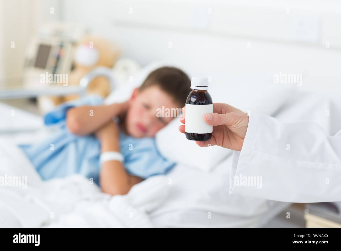 Doctor holding cough syrup with boy in hospital Stock Photo - Alamy