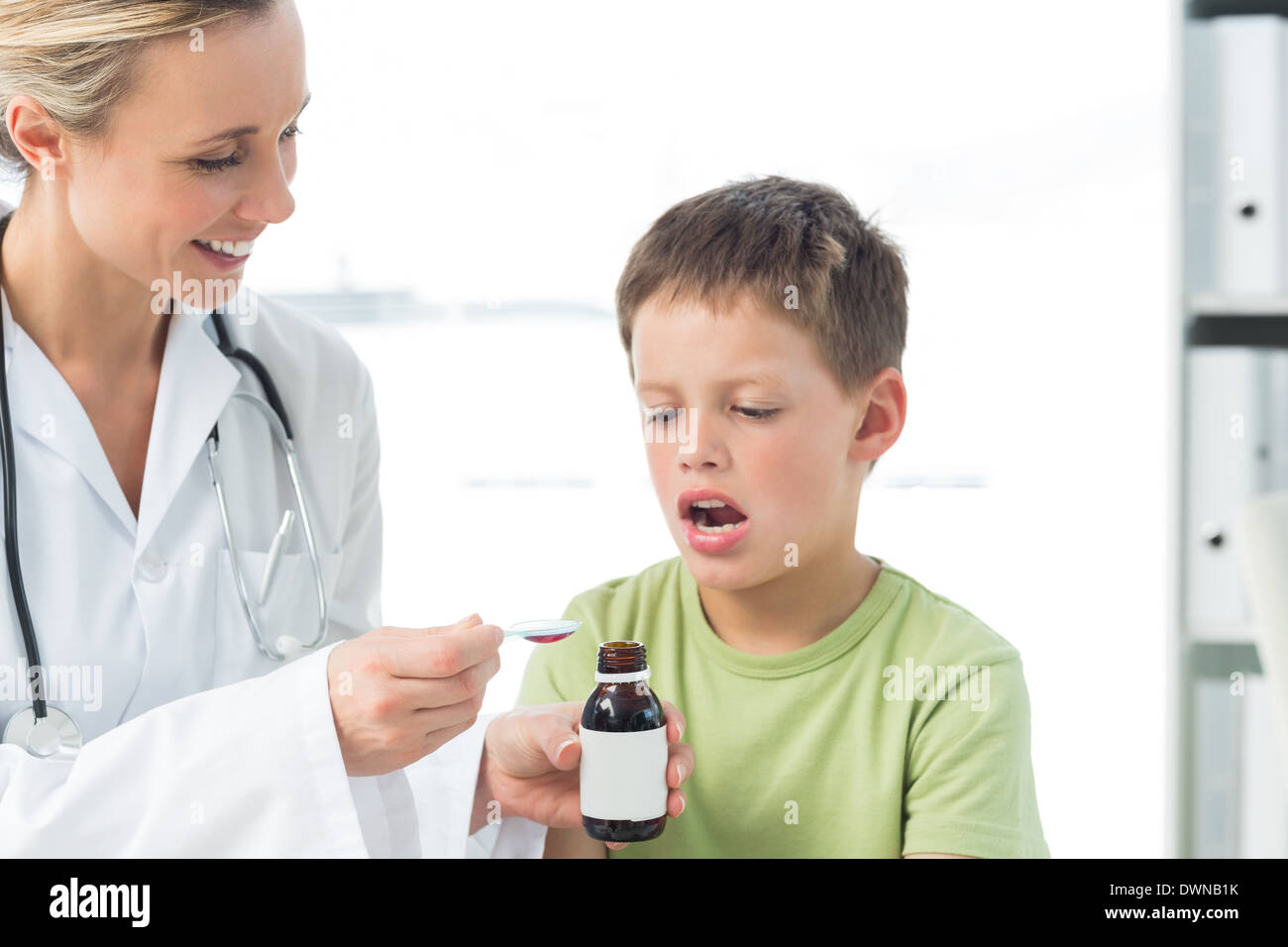 Doctor giving little boy cough syrup Stock Photo - Alamy
