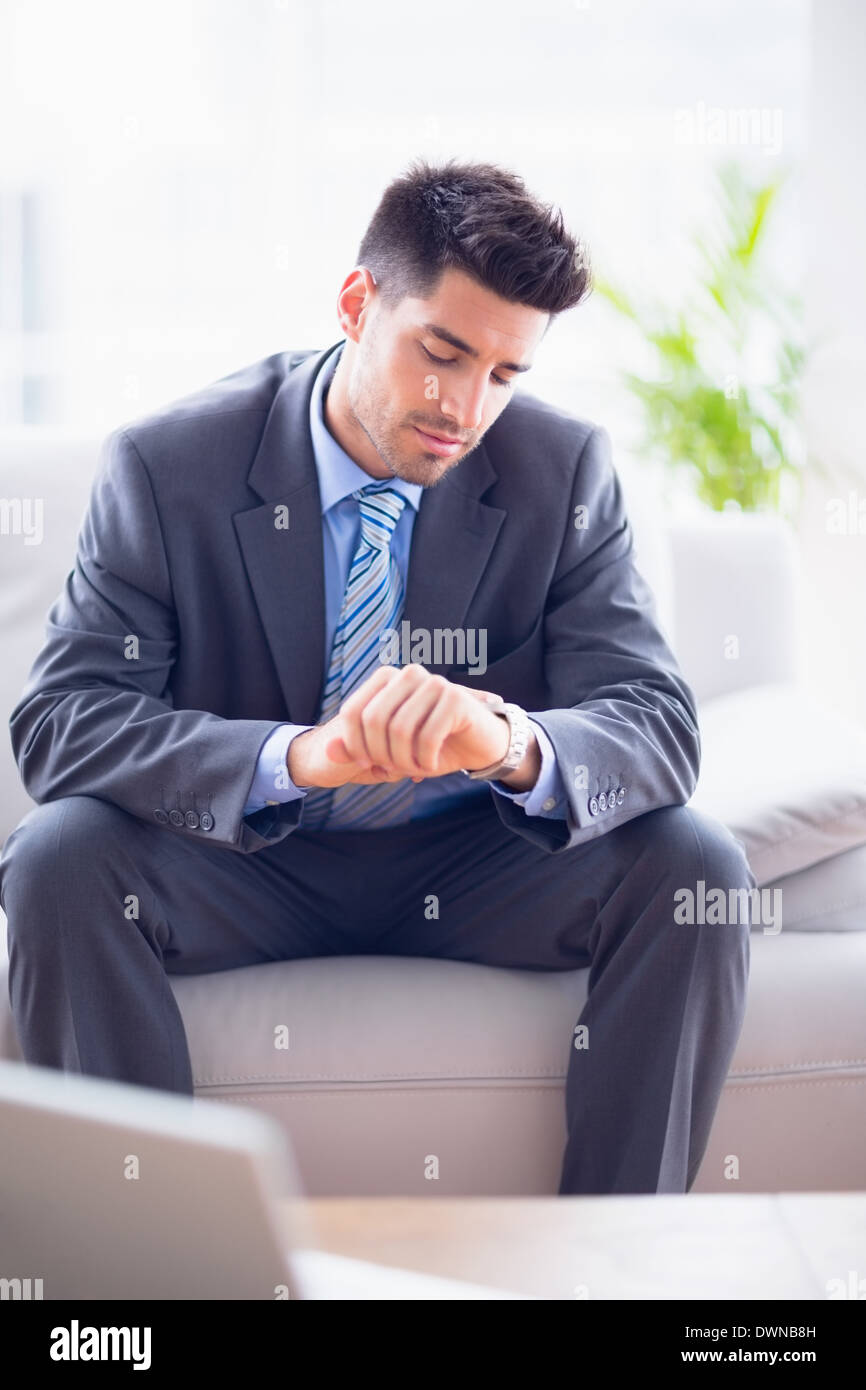 Businessman sitting checking watch smiling hi-res stock photography and ...