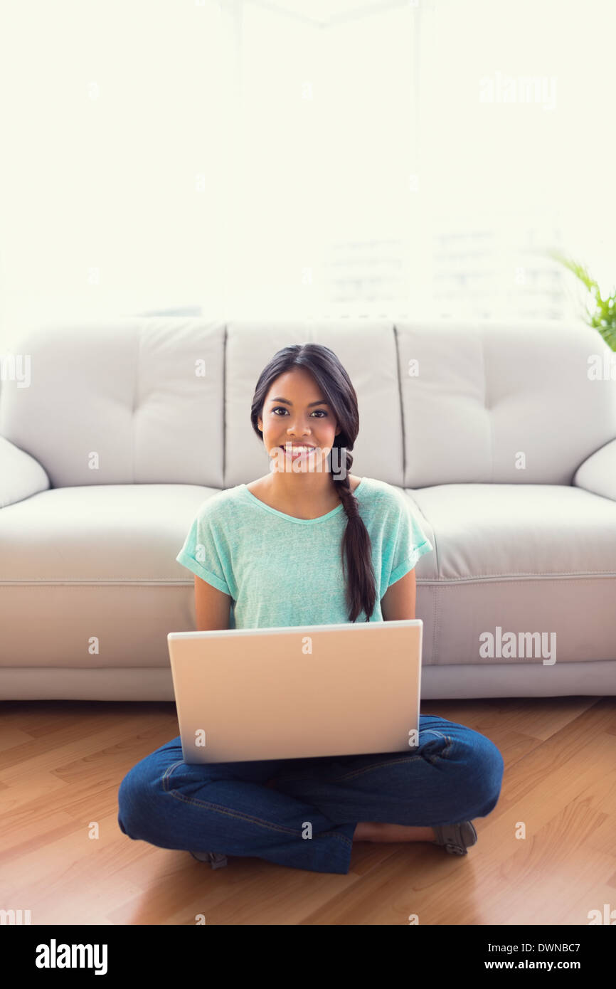 Young girl sitting on floor using her laptop smiling at camera Stock ...
