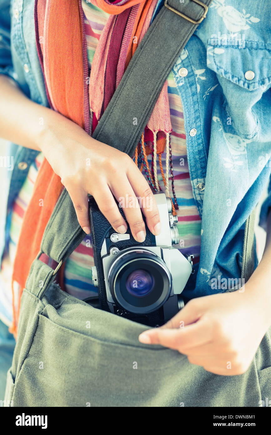 Young woman taking camera from her bag Stock Photo - Alamy