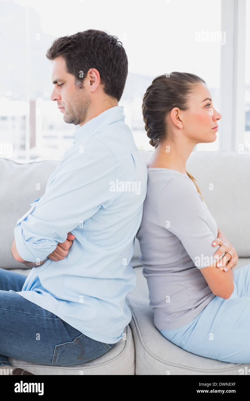 Annoyed couple sitting back to back on the couch Stock Photo - Alamy