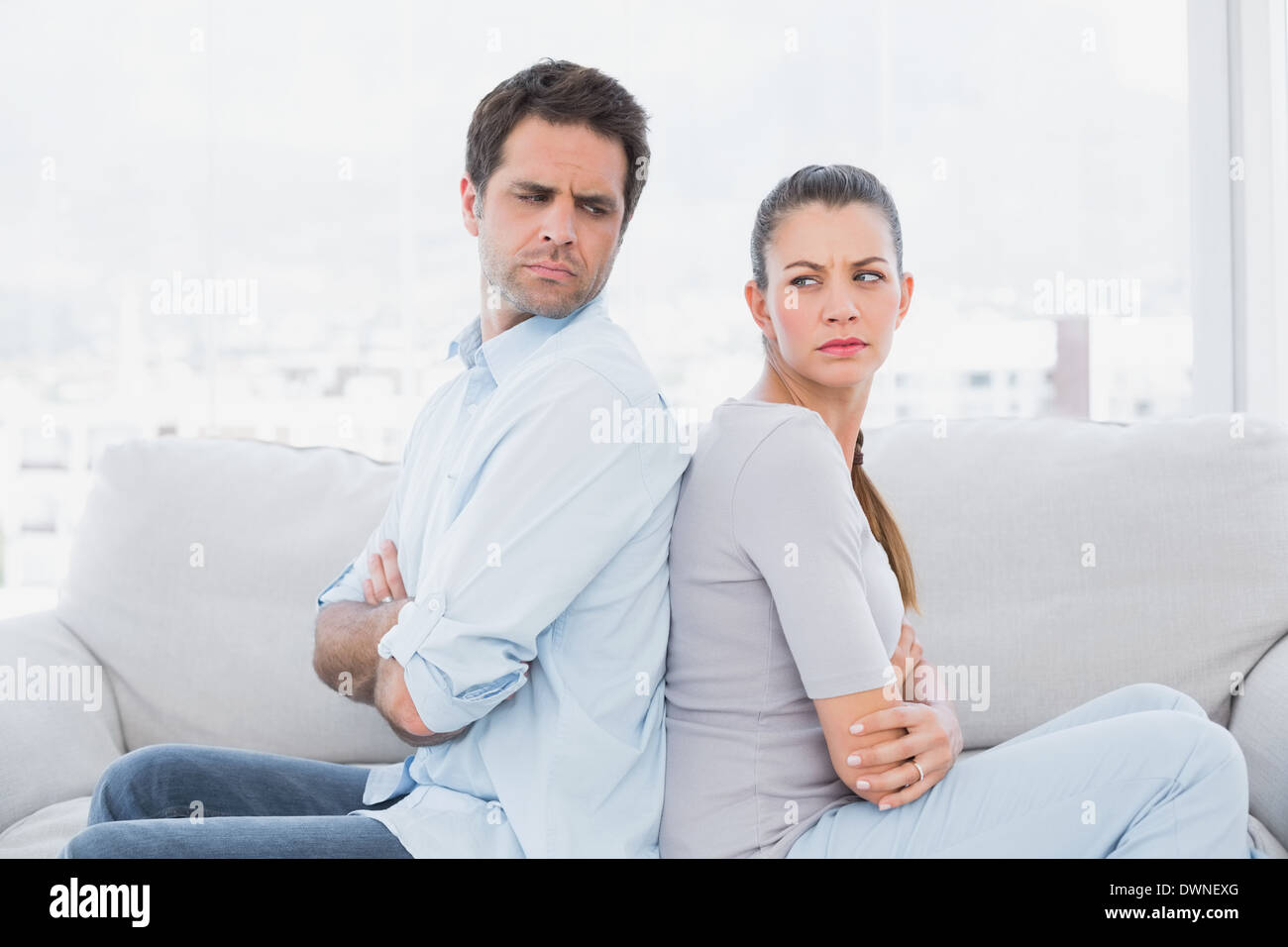 Angry couple sitting back to back on the couch Stock Photo - Alamy