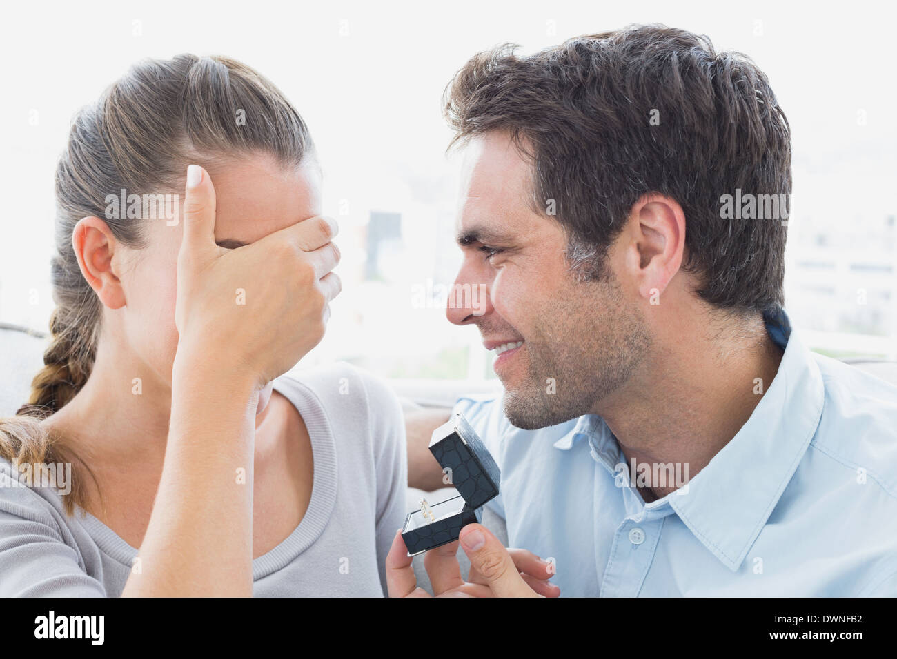 Smiling young couple getting engaged on the sofa Stock Photo - Alamy