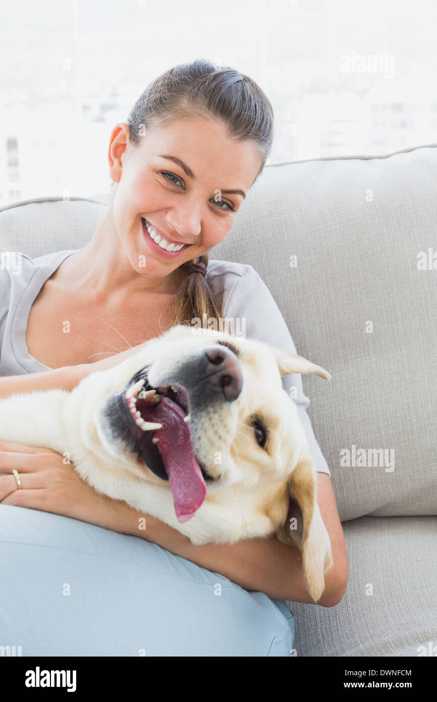 Happy woman cuddling her yellow labrador on the couch Stock Photo - Alamy