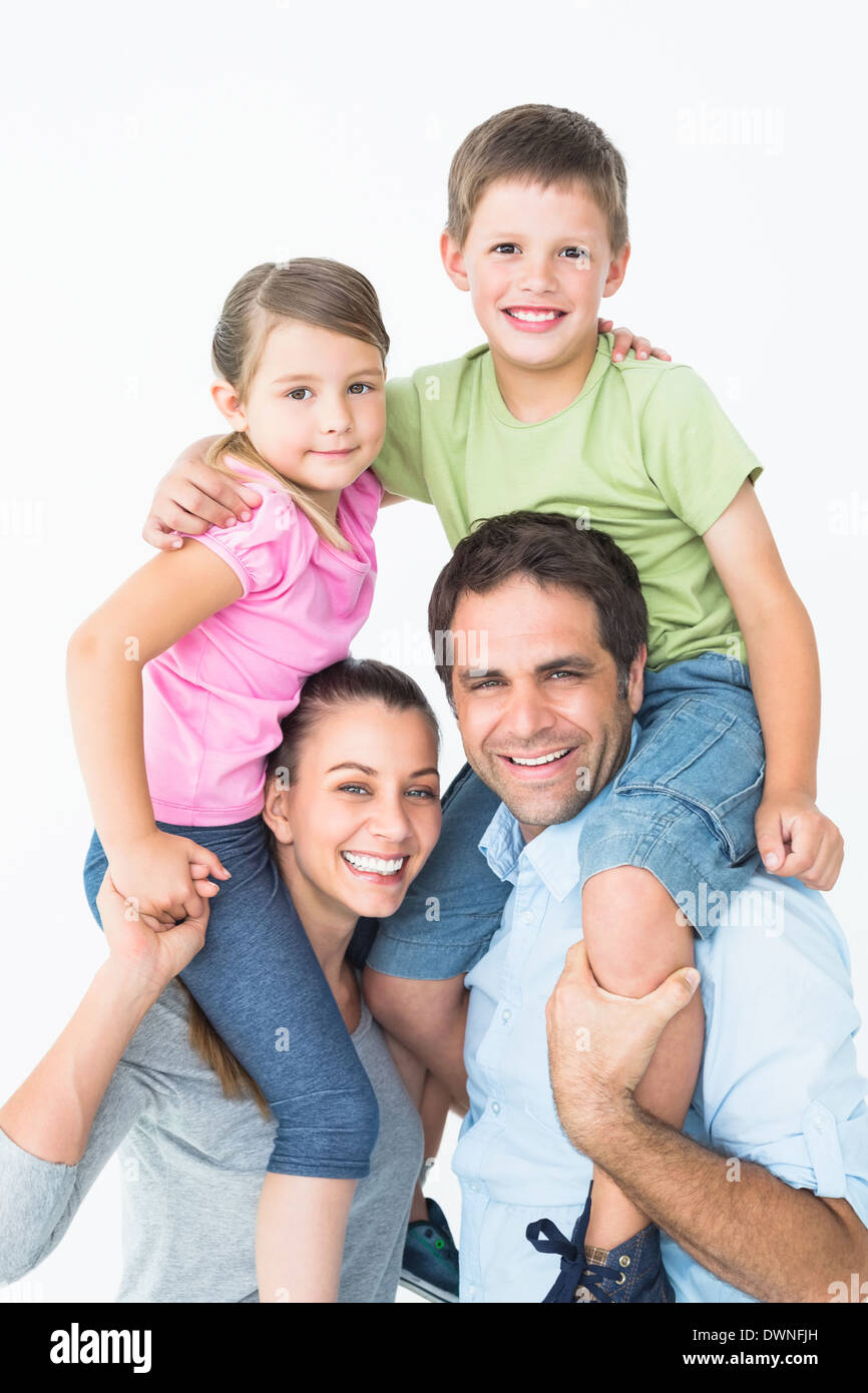 Parents giving their children piggyback ride smiling at camera Stock ...
