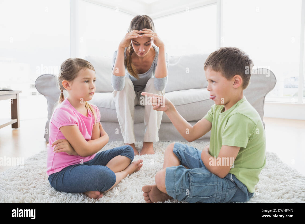 Fed up mother listening to her young children argue Stock Photo - Alamy