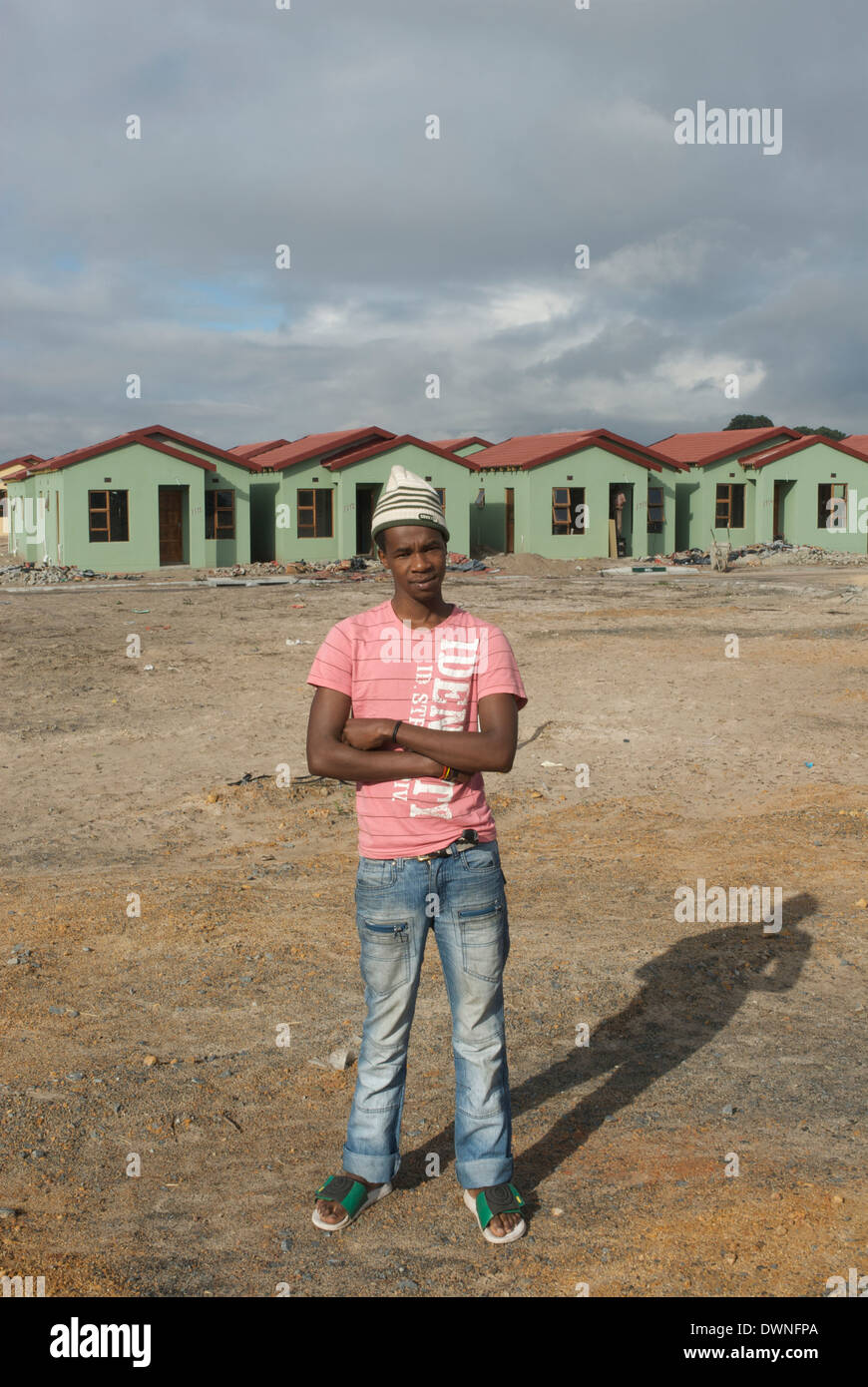A young man stands in front of new homes built outside Atlantis ...