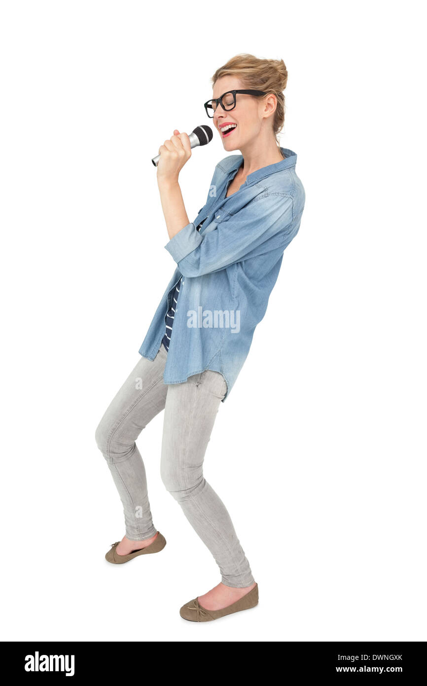 Beautiful young woman singing into a microphone Stock Photo - Alamy