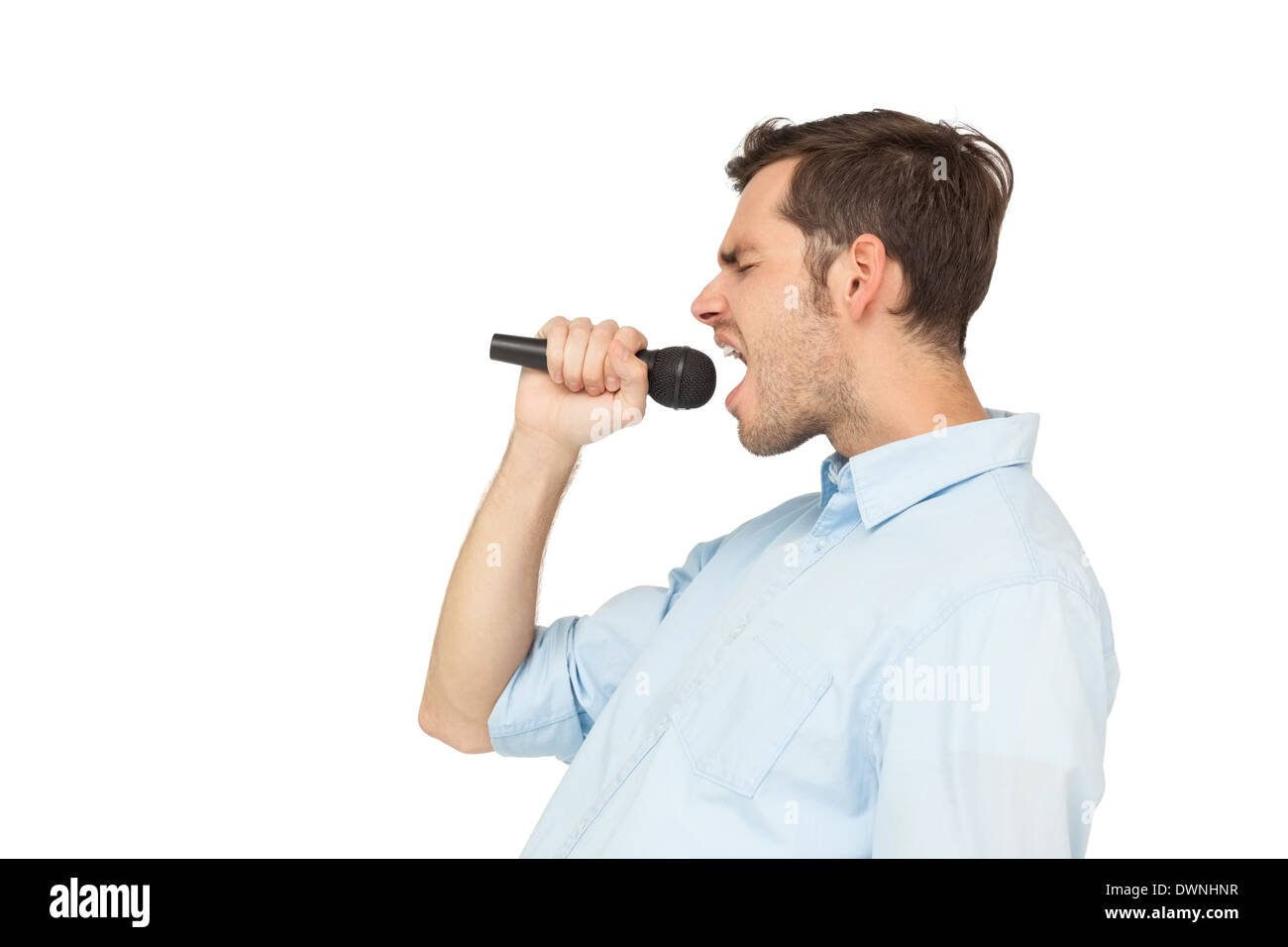 Side view of a young man singing into microphone Stock Photo - Alamy