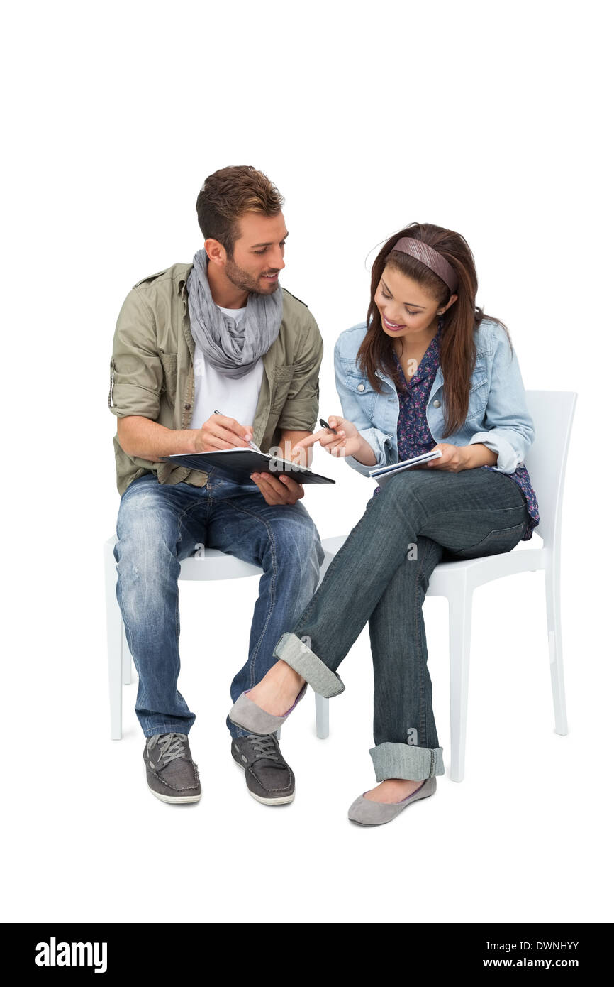 Full length of a cool couple writing in notepads Stock Photo - Alamy