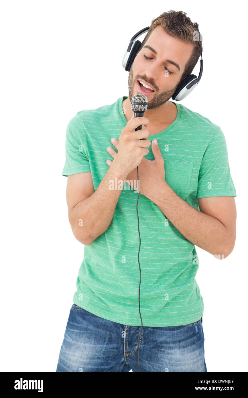 Young man singing into microphone with eyes closed Stock Photo - Alamy