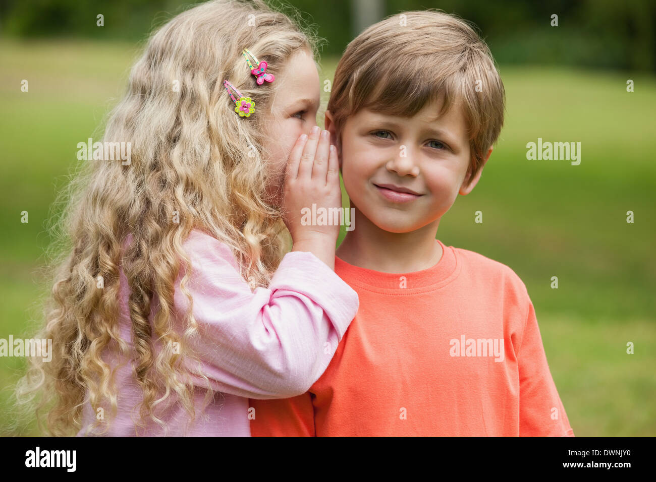 Girl whispering into boys ear hi-res stock photography and images - Alamy