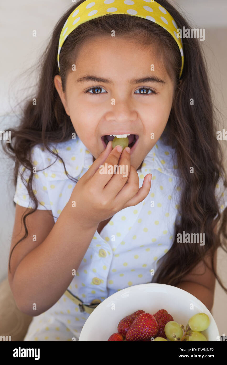 Close-up portrait of a smiling girl eating fruits Stock Photo - Alamy