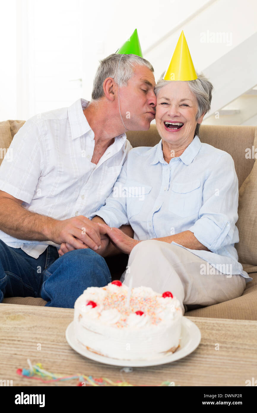 Senior couple sitting on couch celebrating a birthday Stock Photo - Alamy
