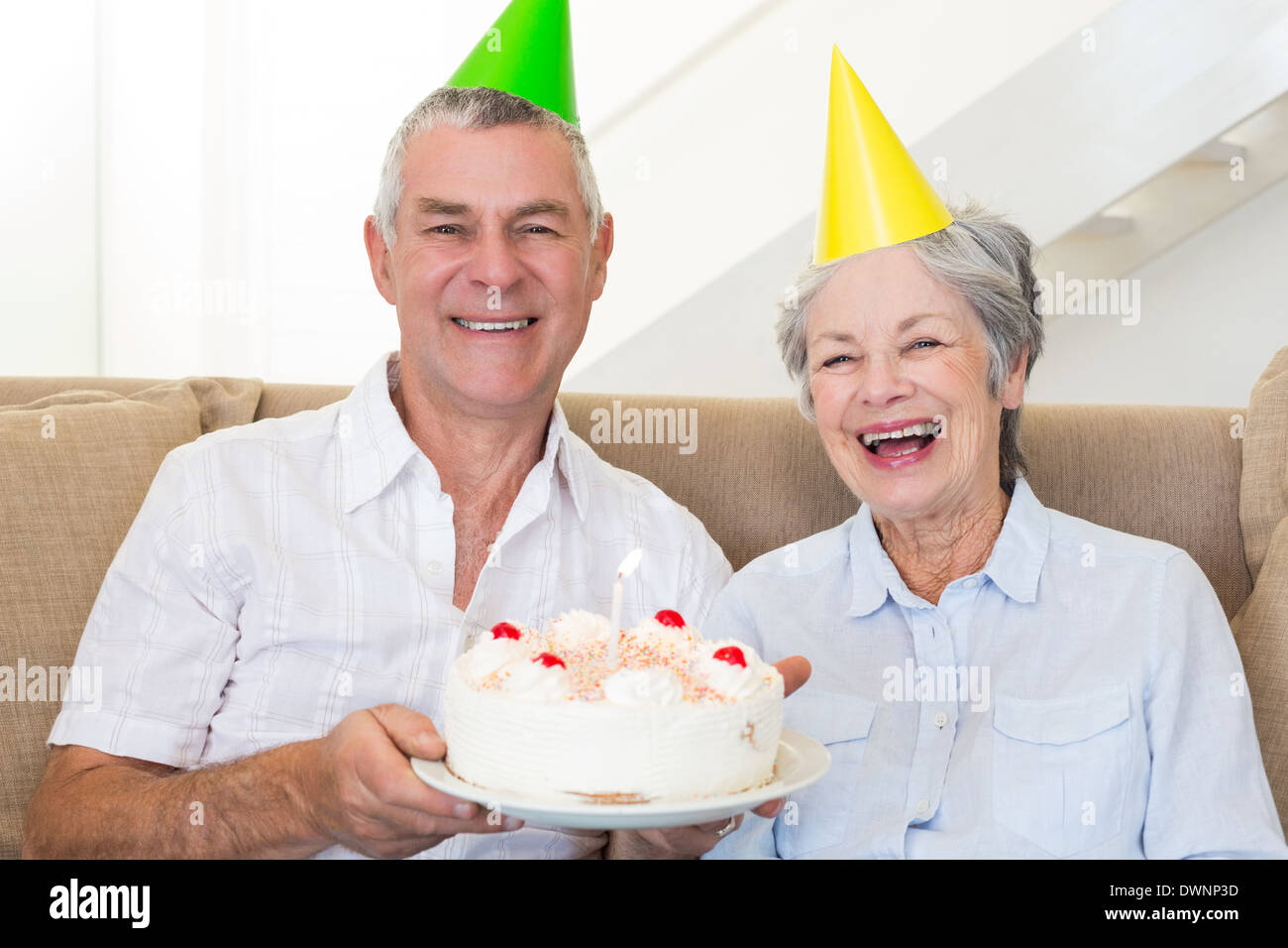 Senior couple sitting on couch celebrating a birthday Stock Photo - Alamy