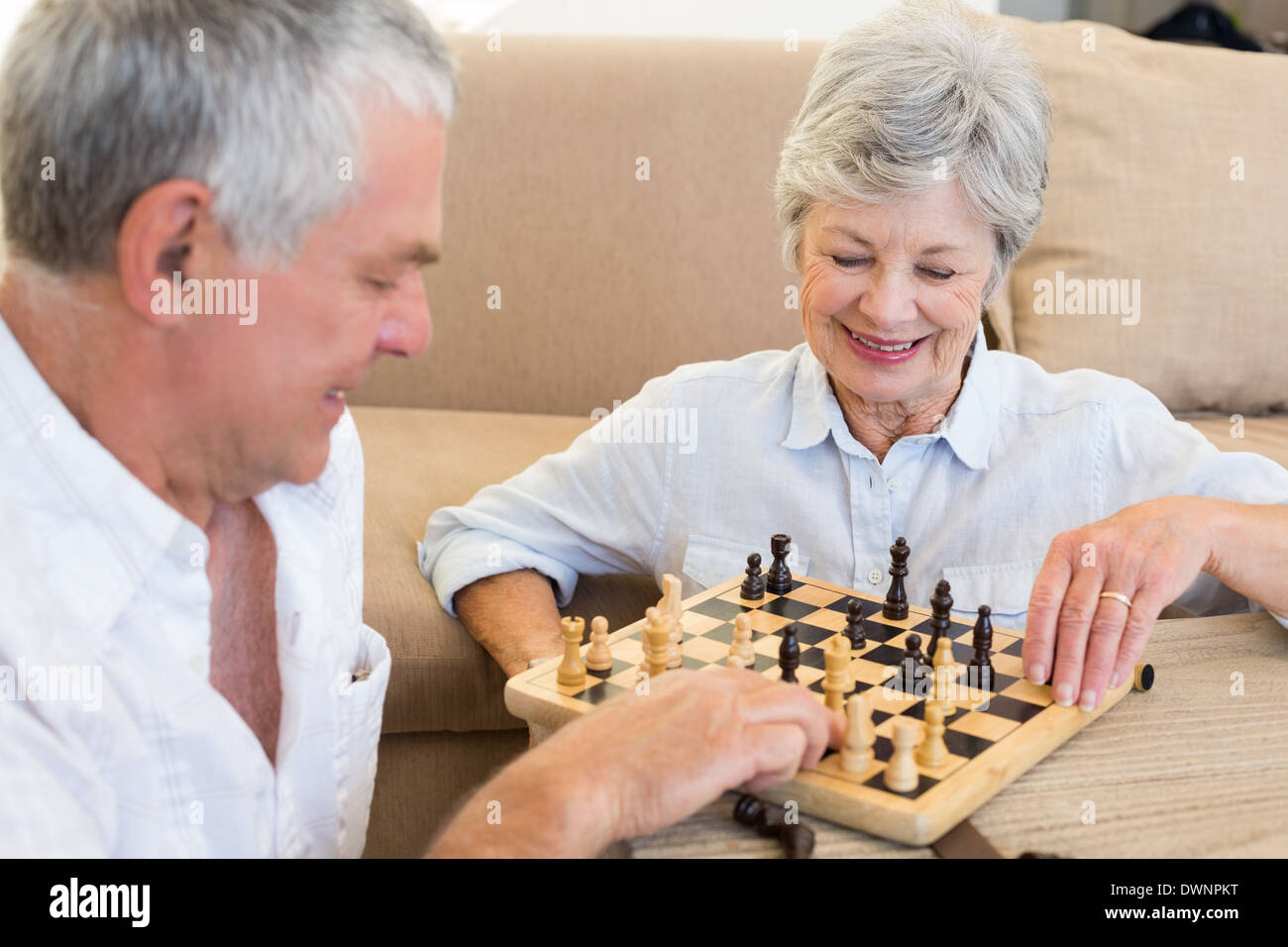 Senior couple sitting on floor playing chess Stock Photo - Alamy