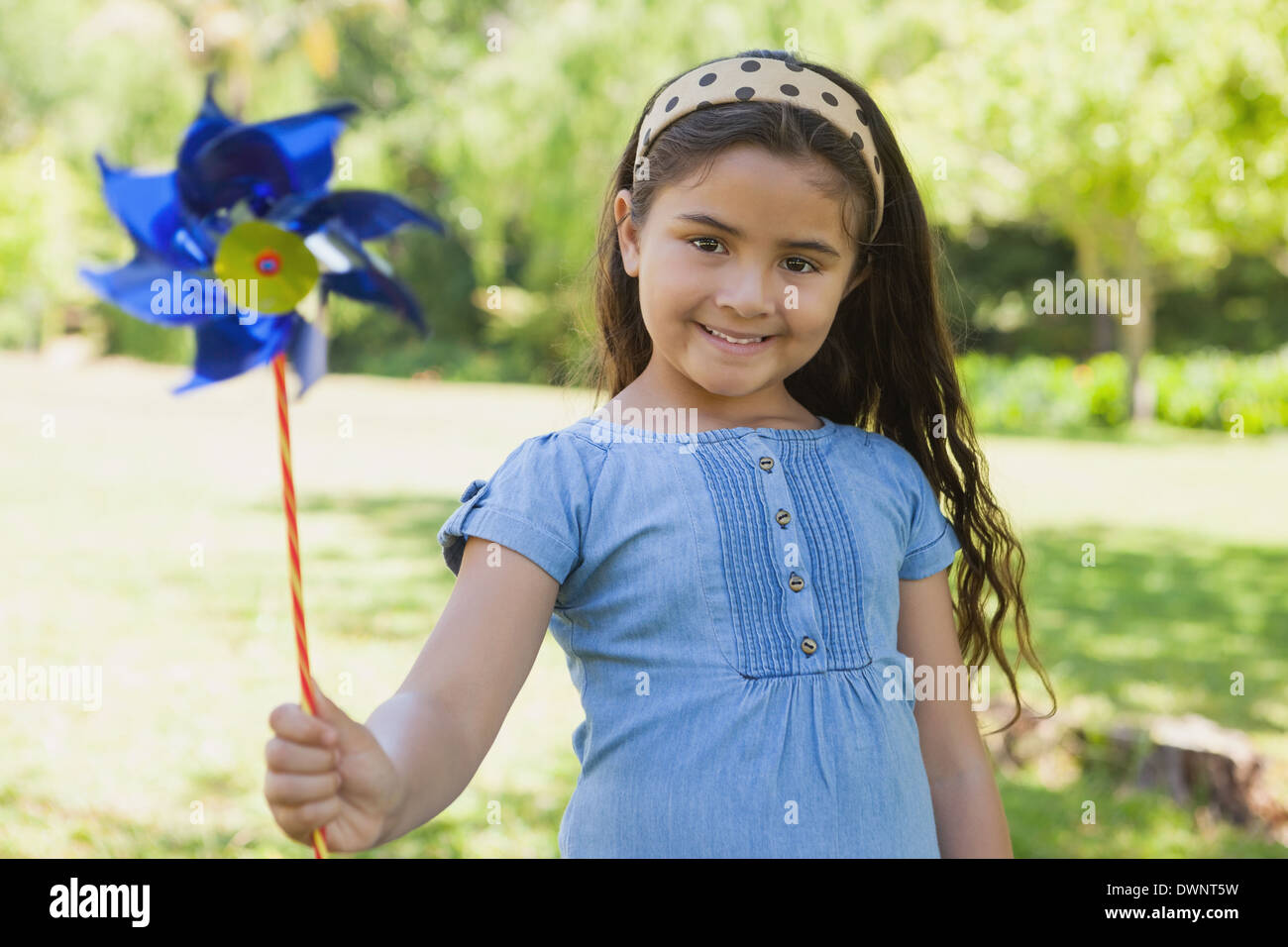 Cute little girl holding pinwheel at park Stock Photo - Alamy