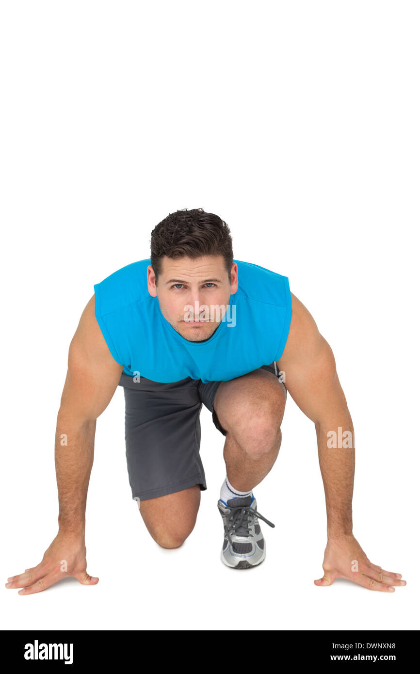 Portrait of a young sporty man in running stance Stock Photo - Alamy