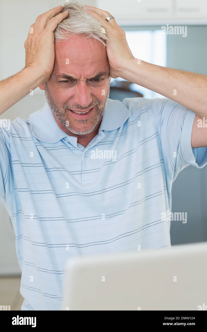 Stressed man using his laptop Stock Photo - Alamy