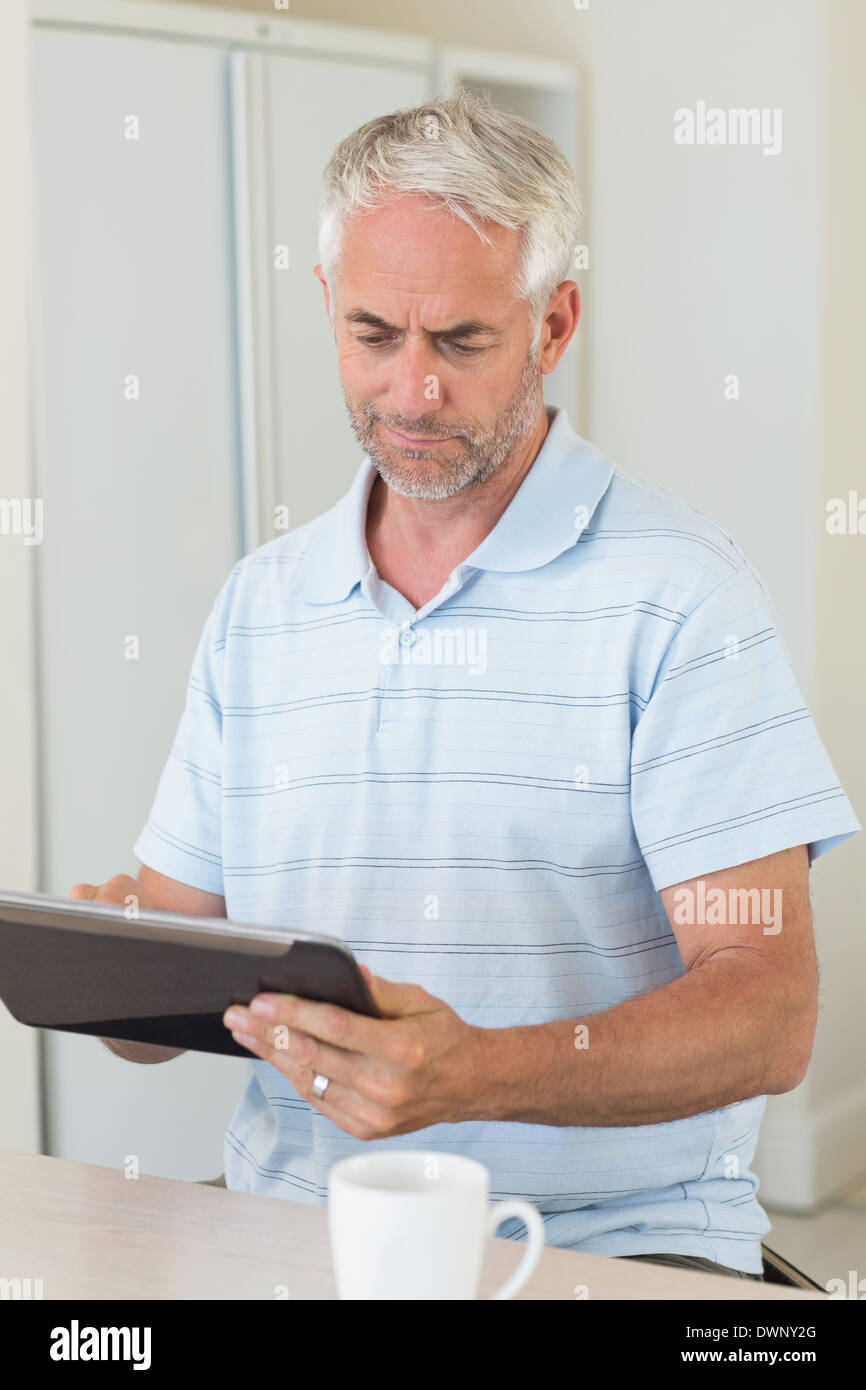 Happy man using his tablet at breakfast Stock Photo - Alamy
