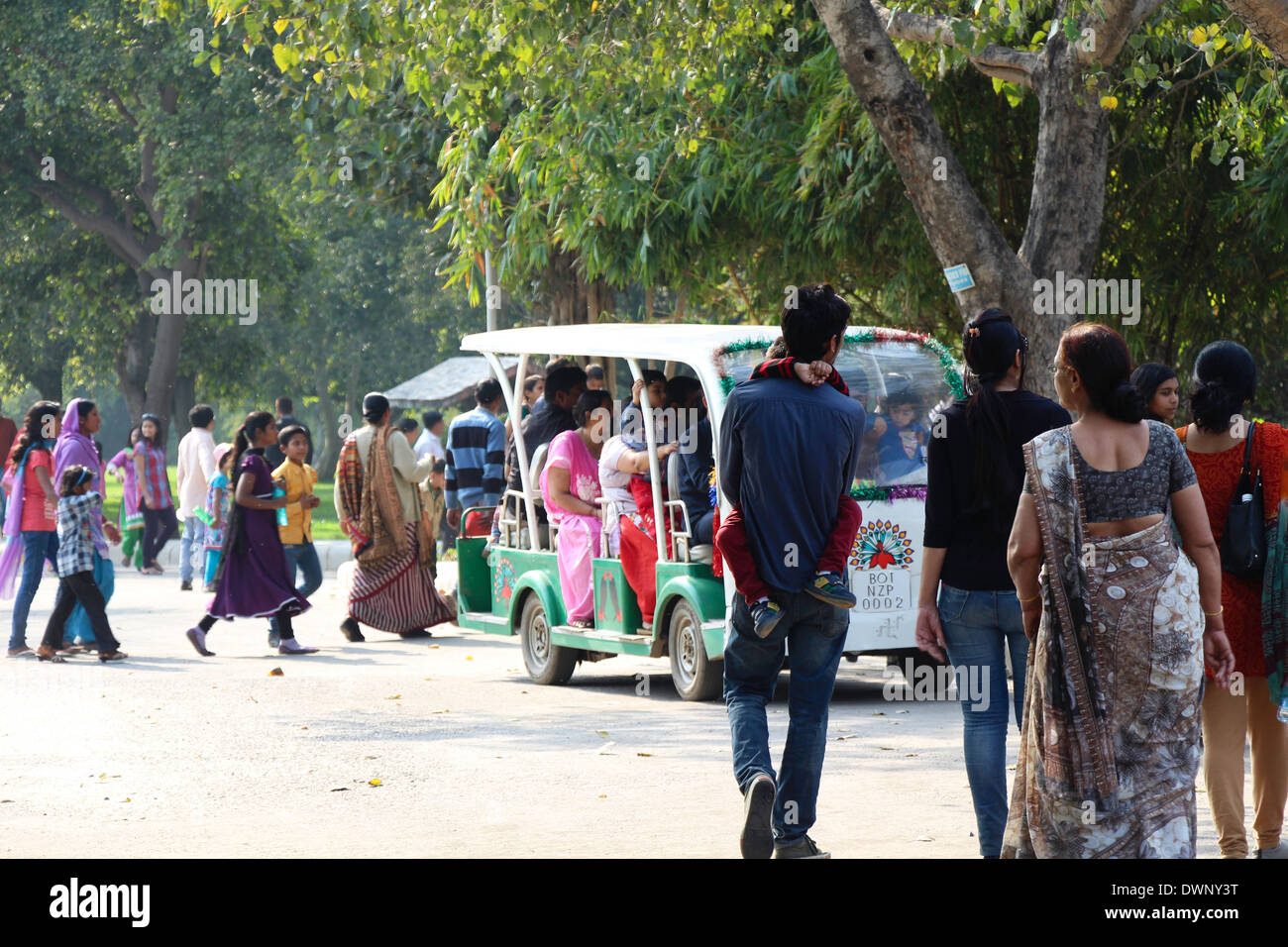 People on a road inside the Delhi Zoo, with a battery operated vehicle ...
