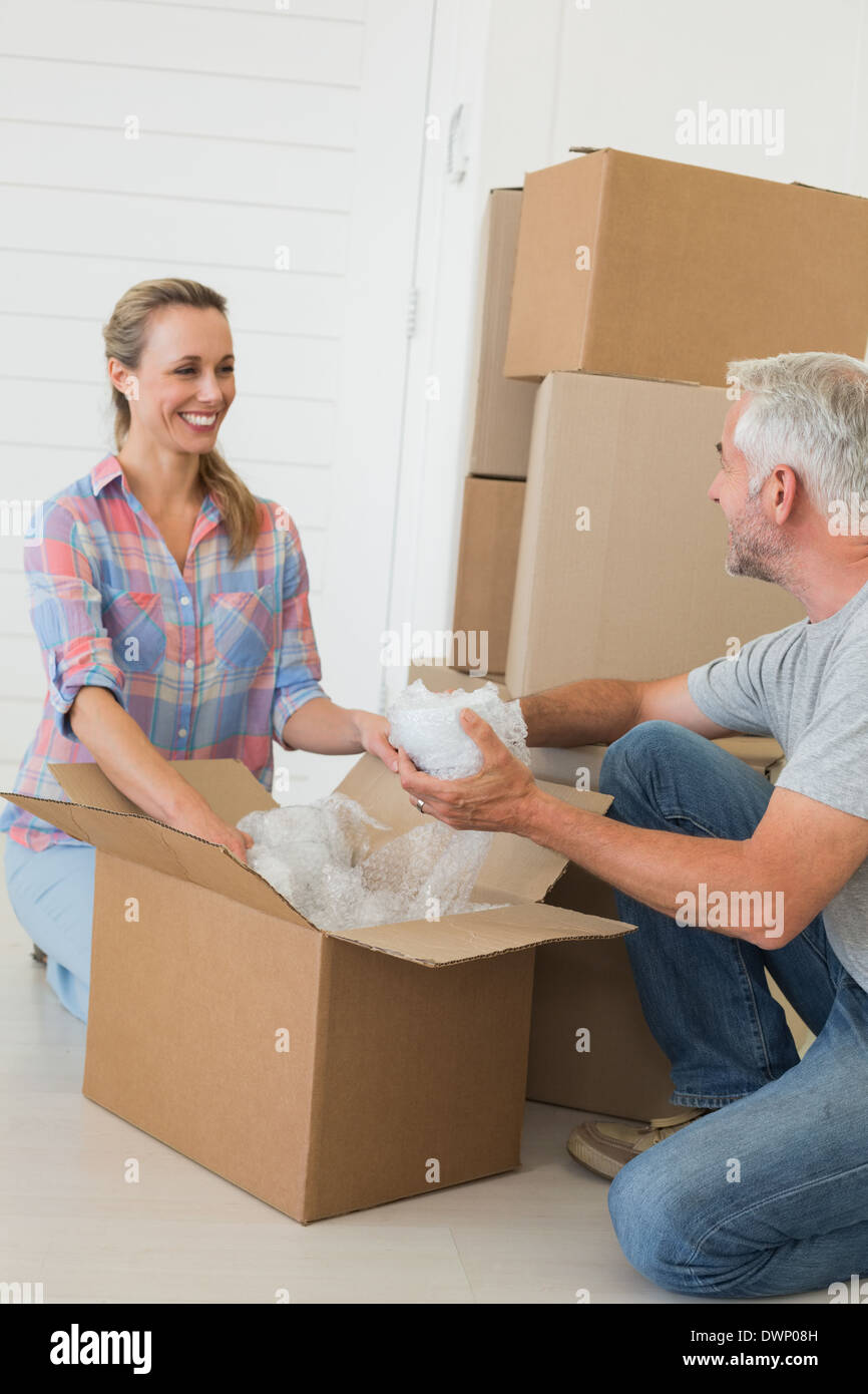 Happy couple unpacking cardboard moving boxes Stock Photo - Alamy