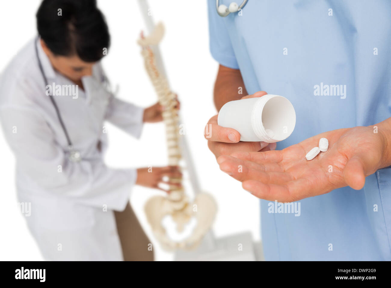 Mid section of doctors with pills and skeleton model Stock Photo - Alamy