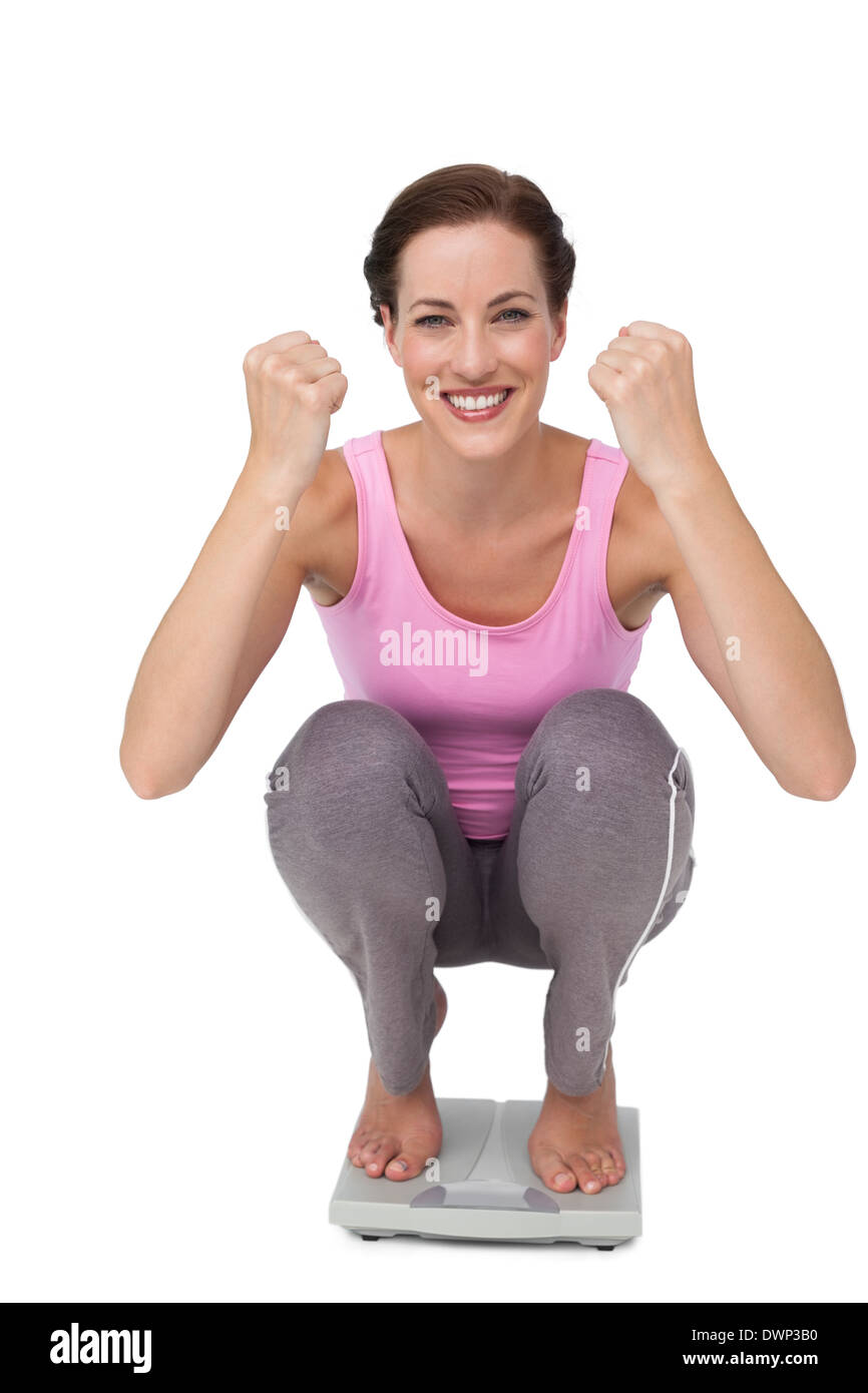 Portrait of a young woman cheering on weight scale Stock Photo - Alamy