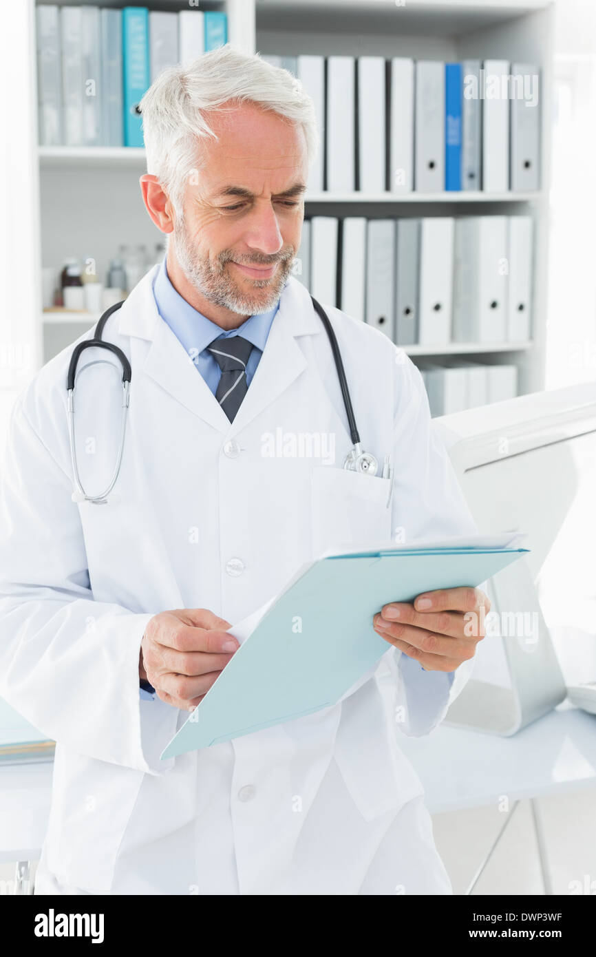 Doctor looking at a folder in the medical office Stock Photo - Alamy