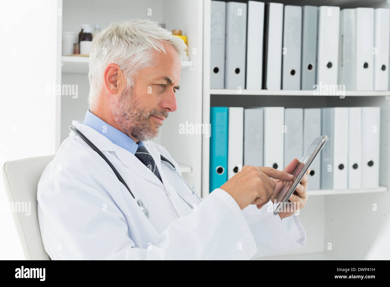 Concentrated doctor using digital tablet at medical office Stock Photo ...