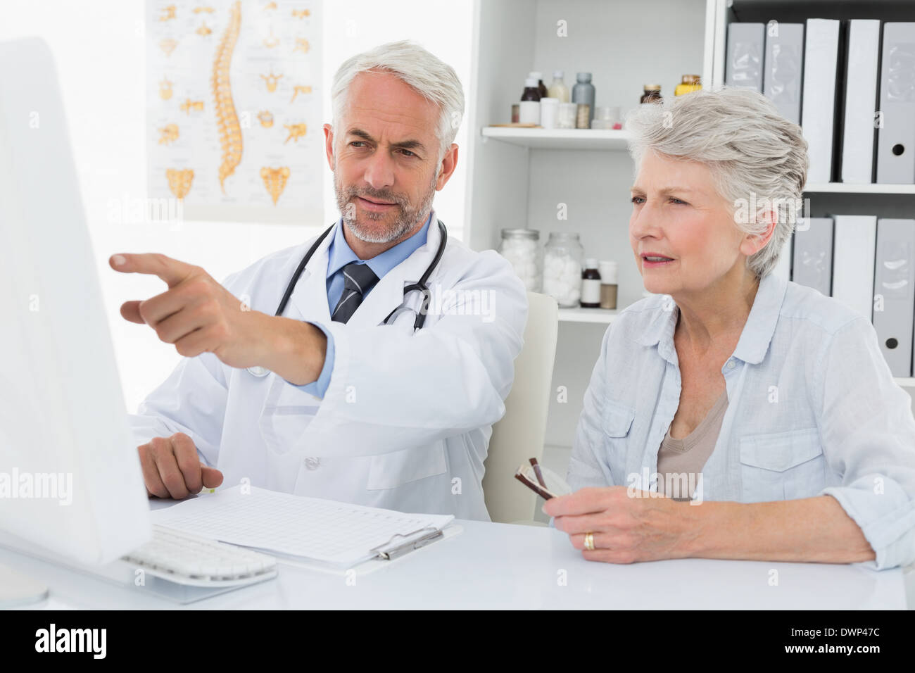 Doctor with female patient reading reports on computer Stock Photo - Alamy