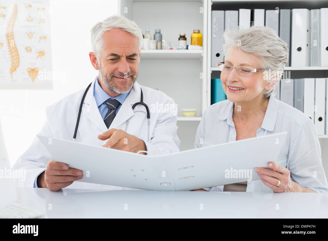 Doctor with female patient reading reports Stock Photo - Alamy