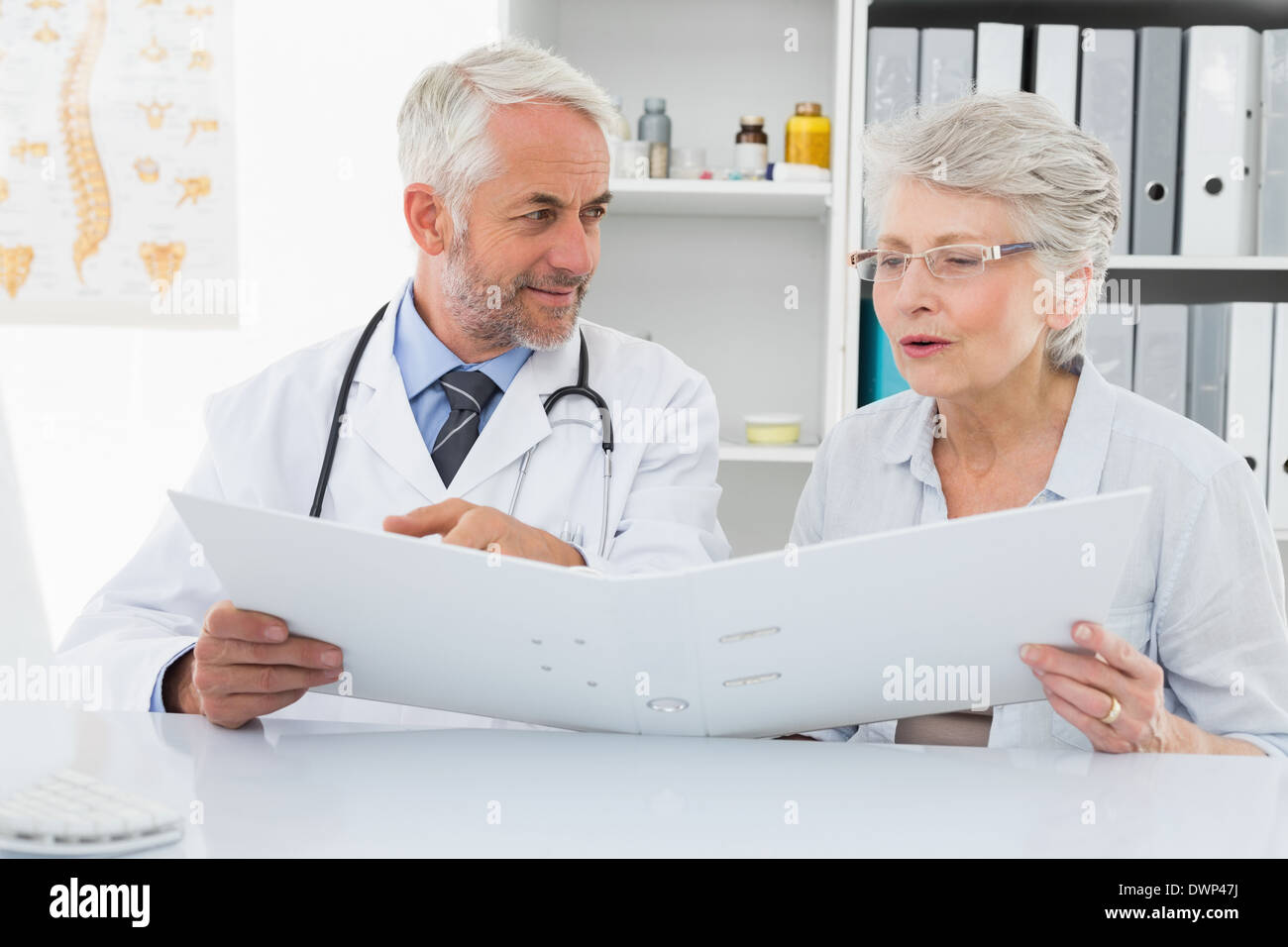 Doctor with patient reading reports at medical office Stock Photo - Alamy