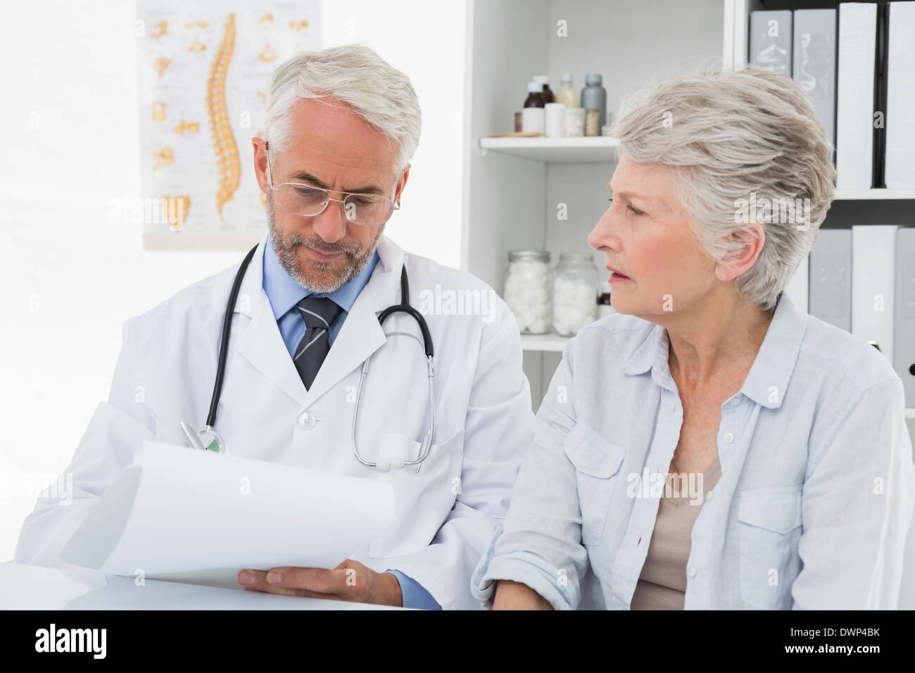 Doctor with female patient reading reports Stock Photo - Alamy