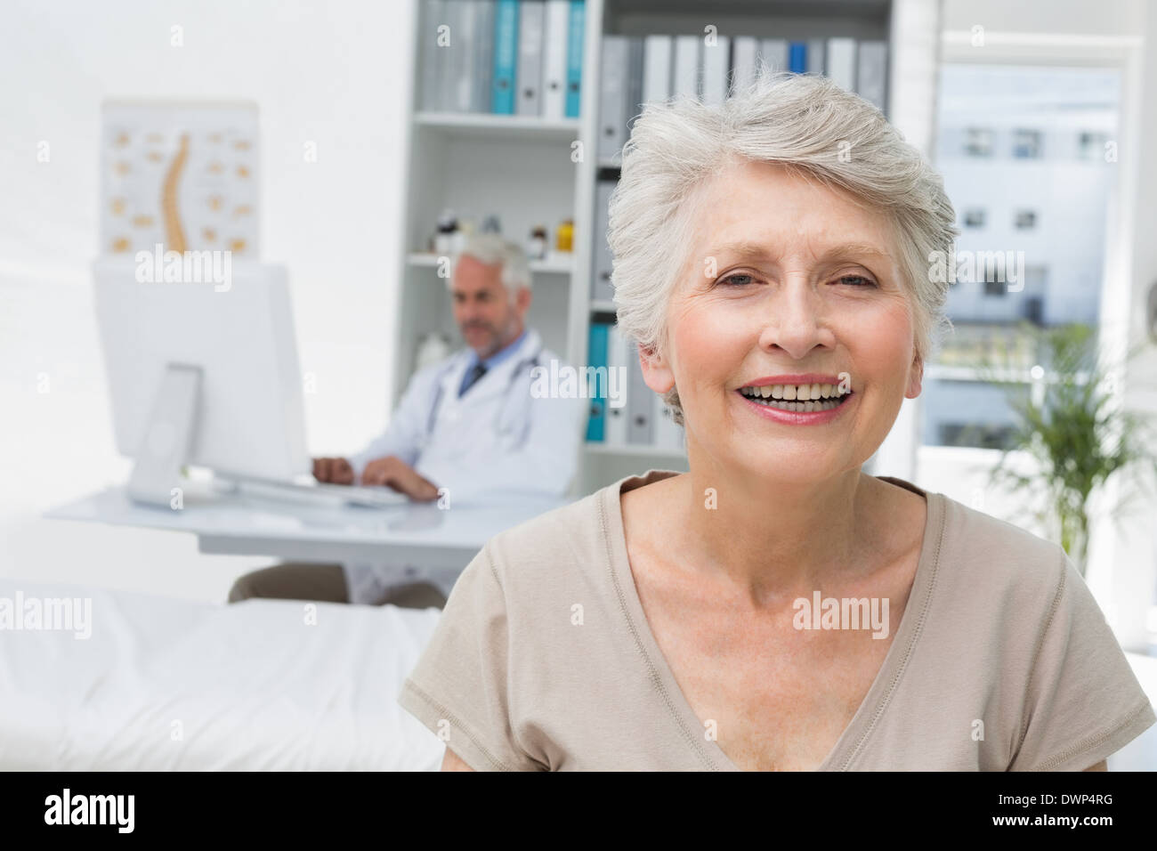 Happy senior patient with doctor at medical office Stock Photo - Alamy