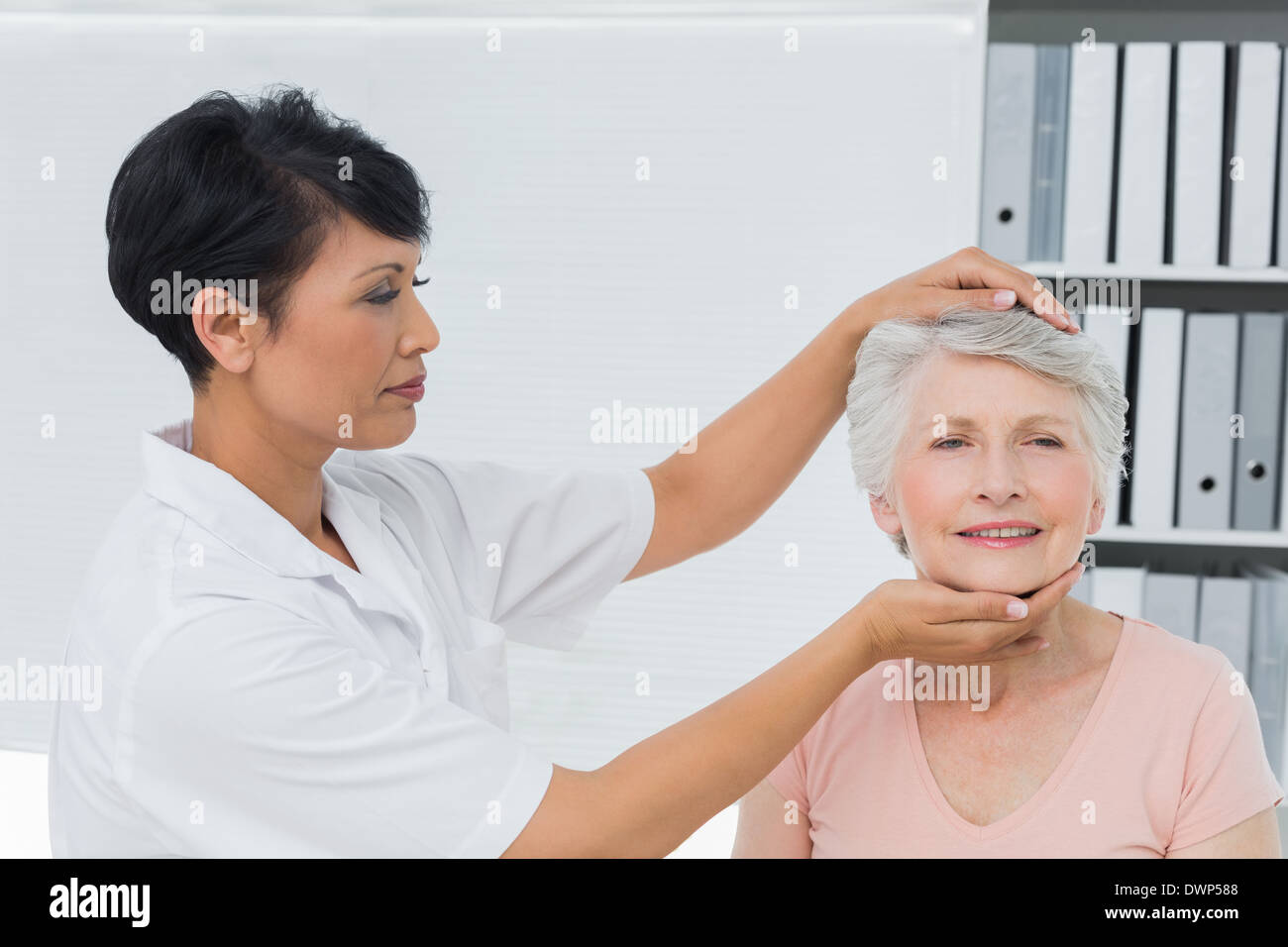 Female chiropractor doing neck adjustment Stock Photo - Alamy