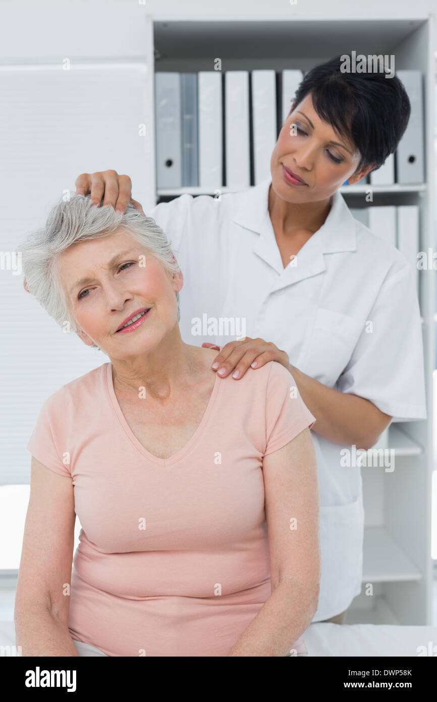 Female chiropractor doing neck adjustment Stock Photo - Alamy